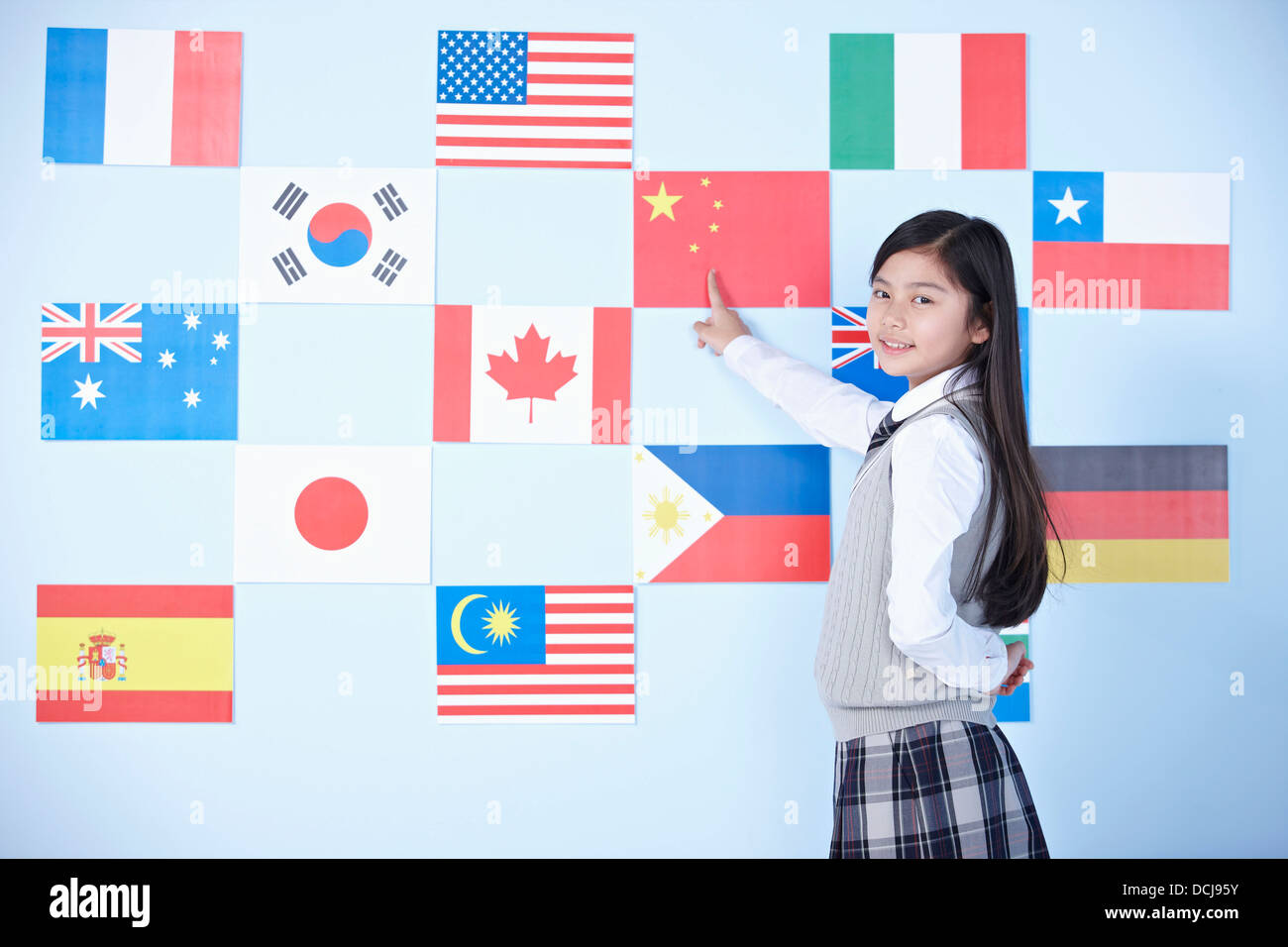 a student in uniform pointing at one of international flags Stock Photo ...