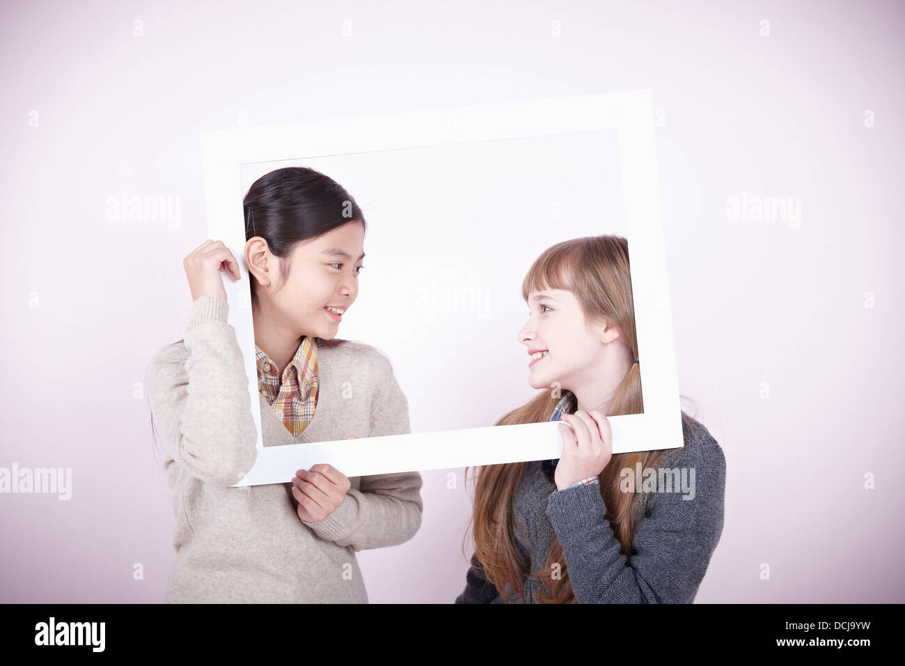 two girls with empty frame around themselves Stock Photo - Alamy