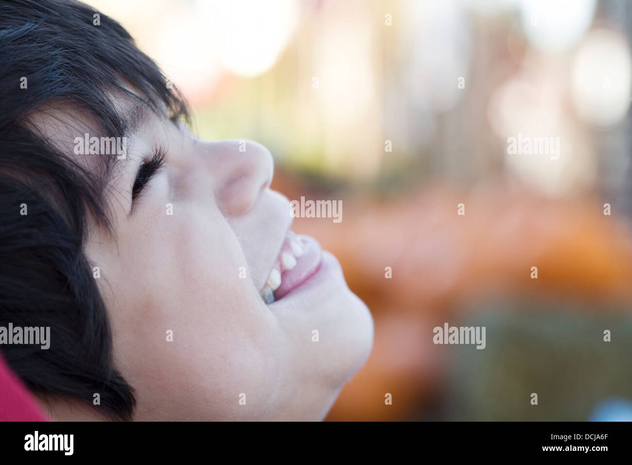 Happy little boy smiling up, profile Stock Photo - Alamy