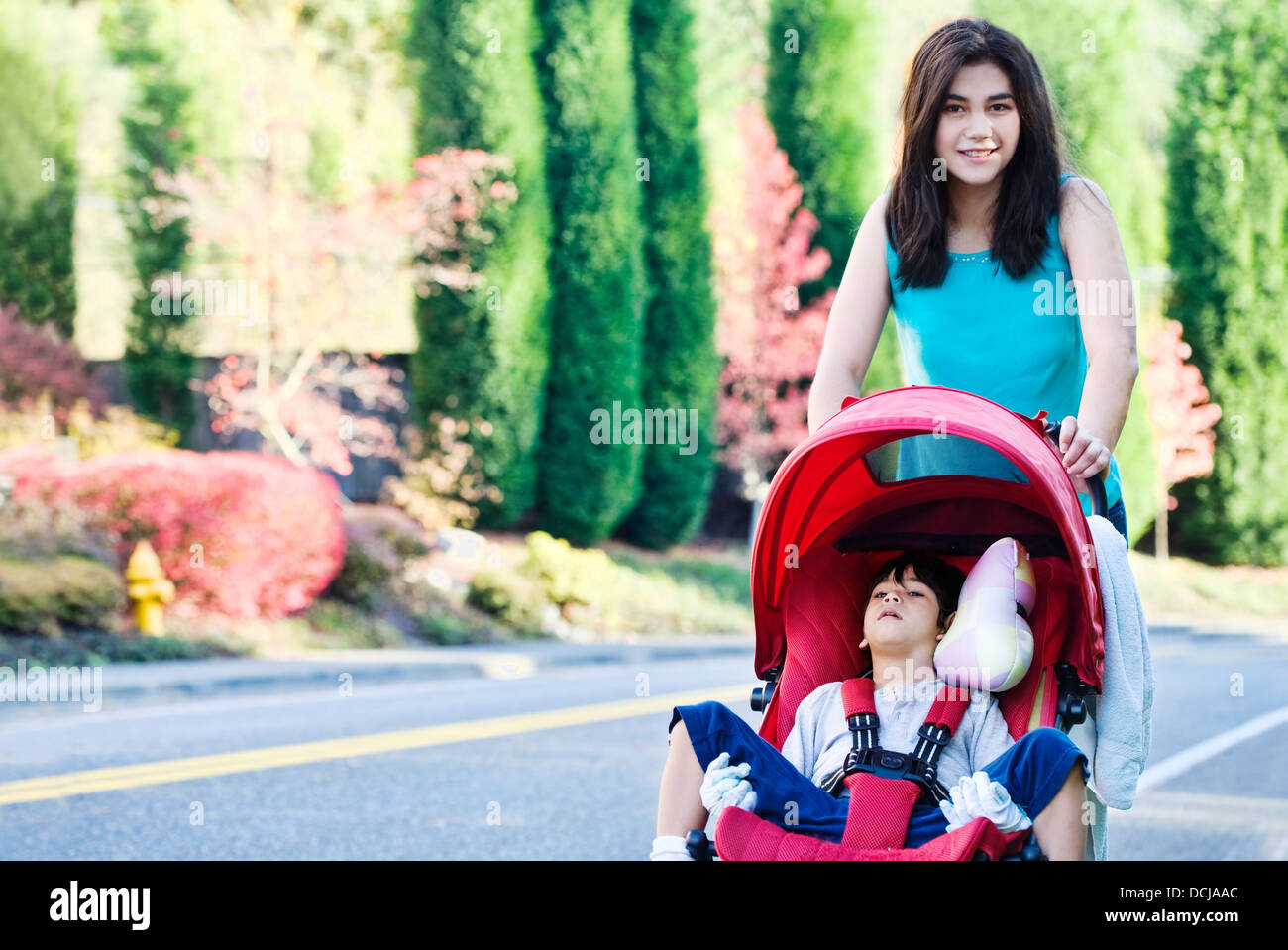 Teen girl pushing her little brother in stroller Stock Photo - Alamy