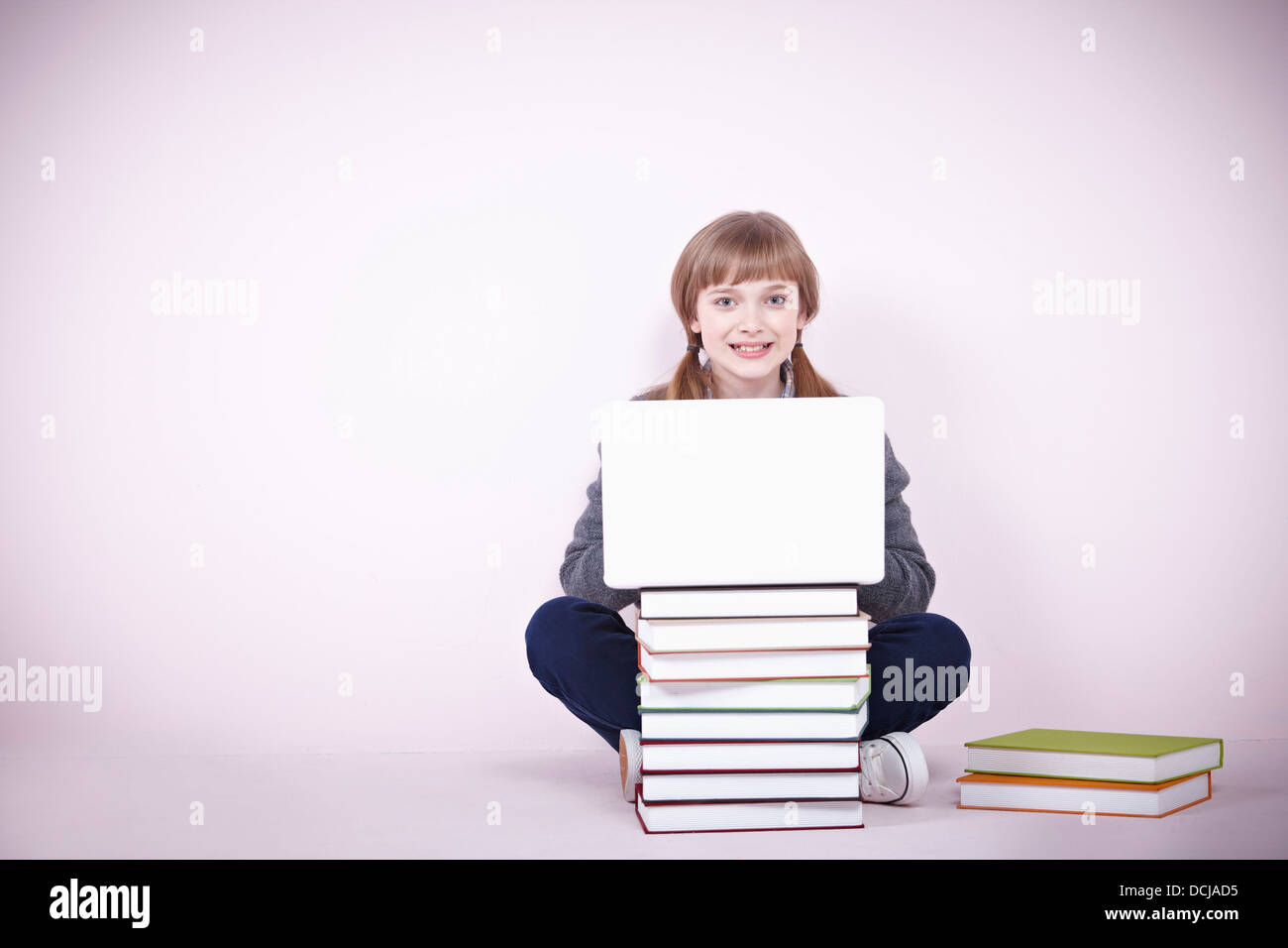 a girl with several books and a laptop Stock Photo - Alamy