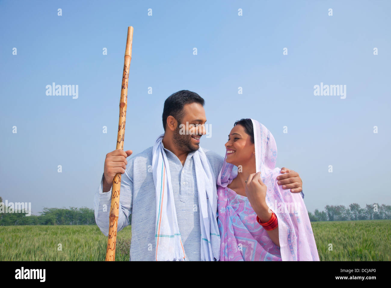 Indian couple smiling while looking at each other Stock Photo - Alamy