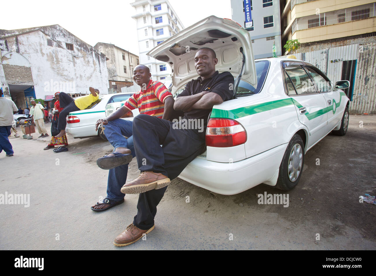 Taxi drivers sat in a car boot at a taxi rank awaiting business, Dar es ...
