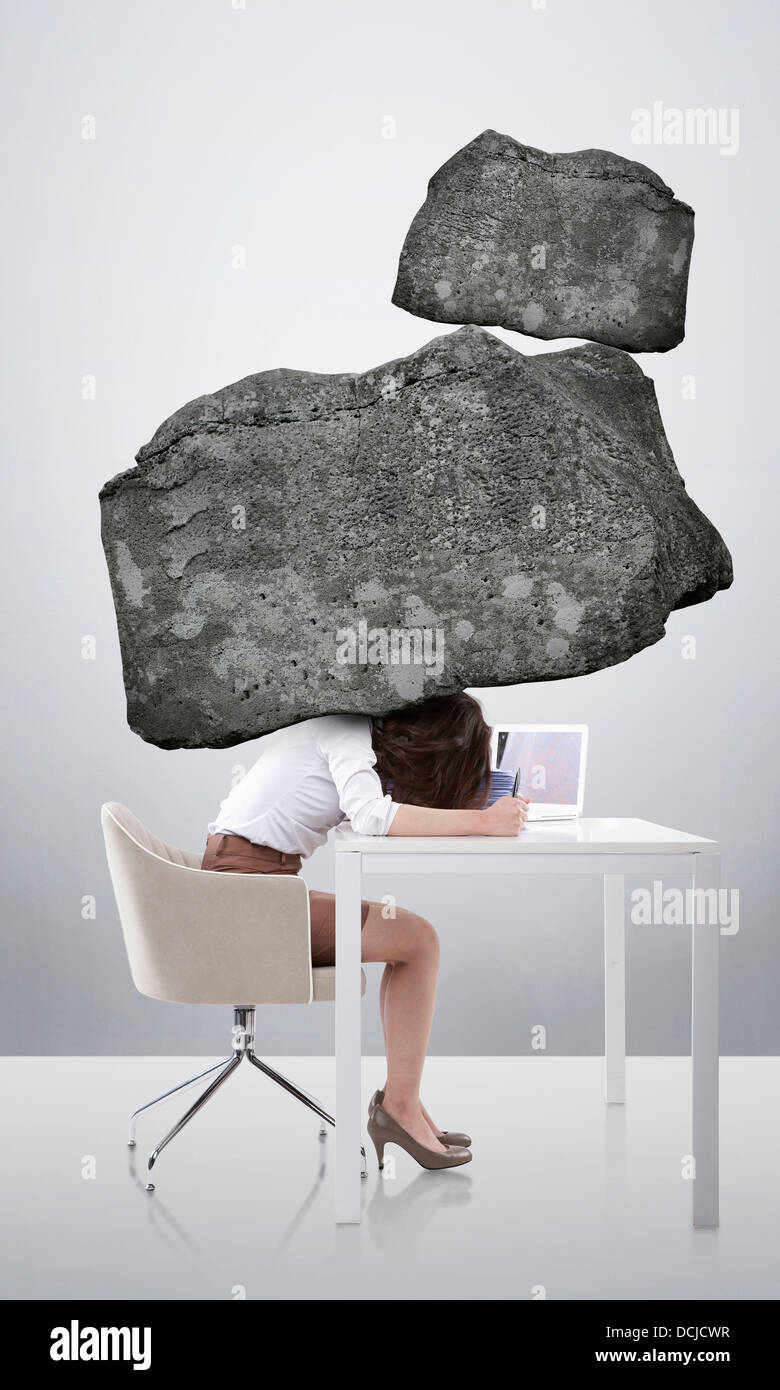 a business woman at her desk being crushed by rocks Stock Photo - Alamy