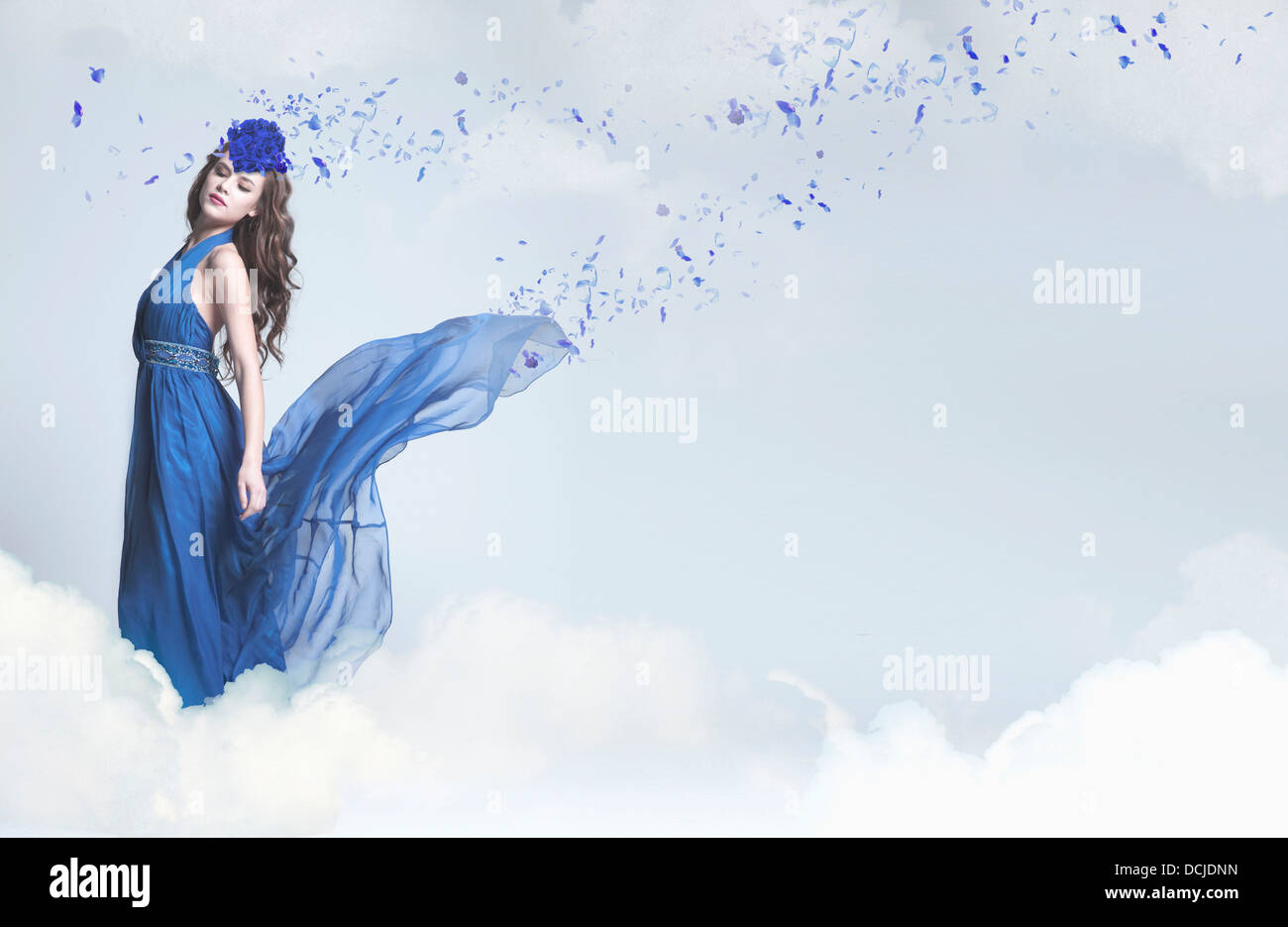 a woman dressed in blue standing on a cloud Stock Photo - Alamy