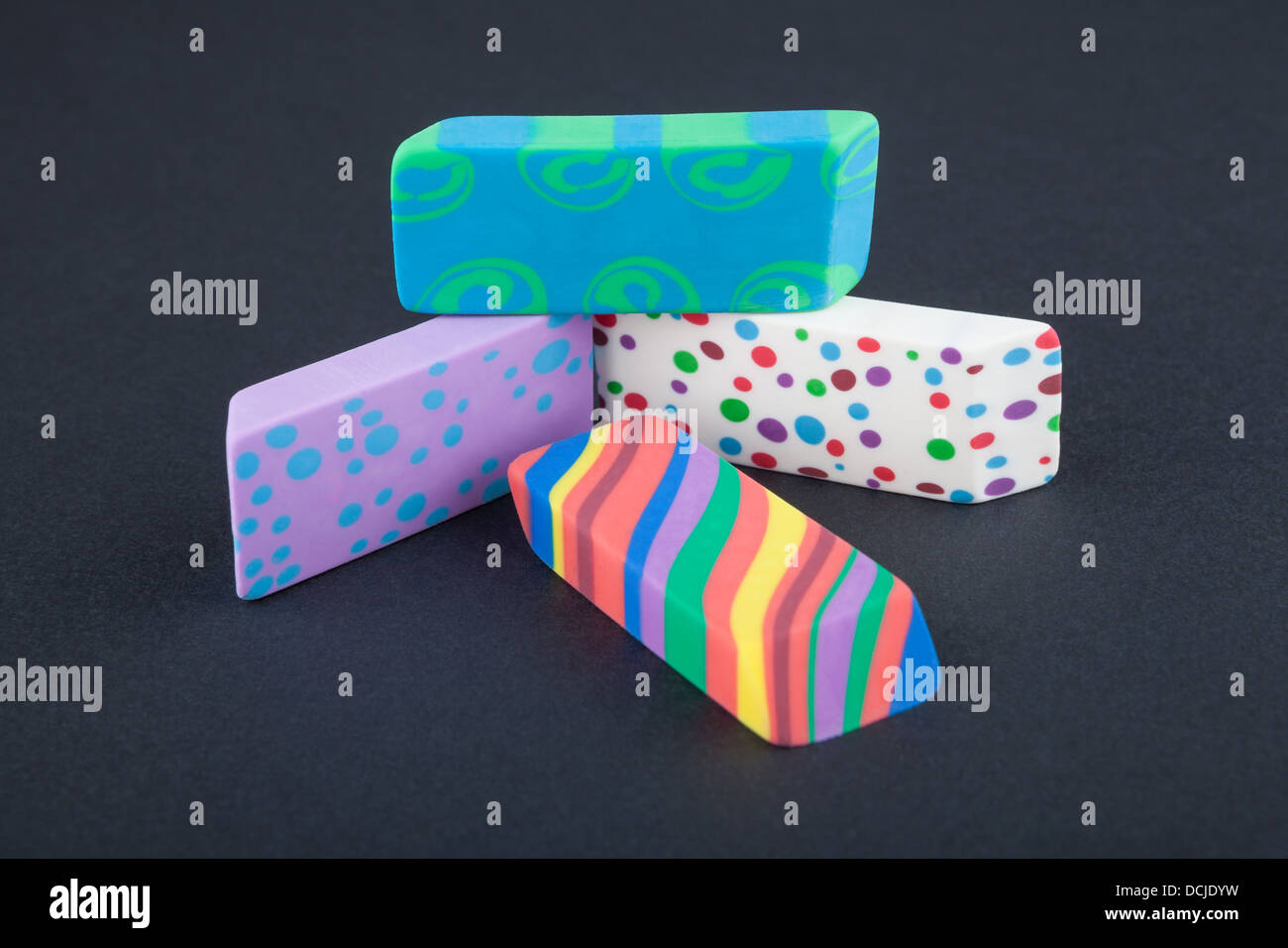 Four colored eraser on the black background Stock Photo - Alamy