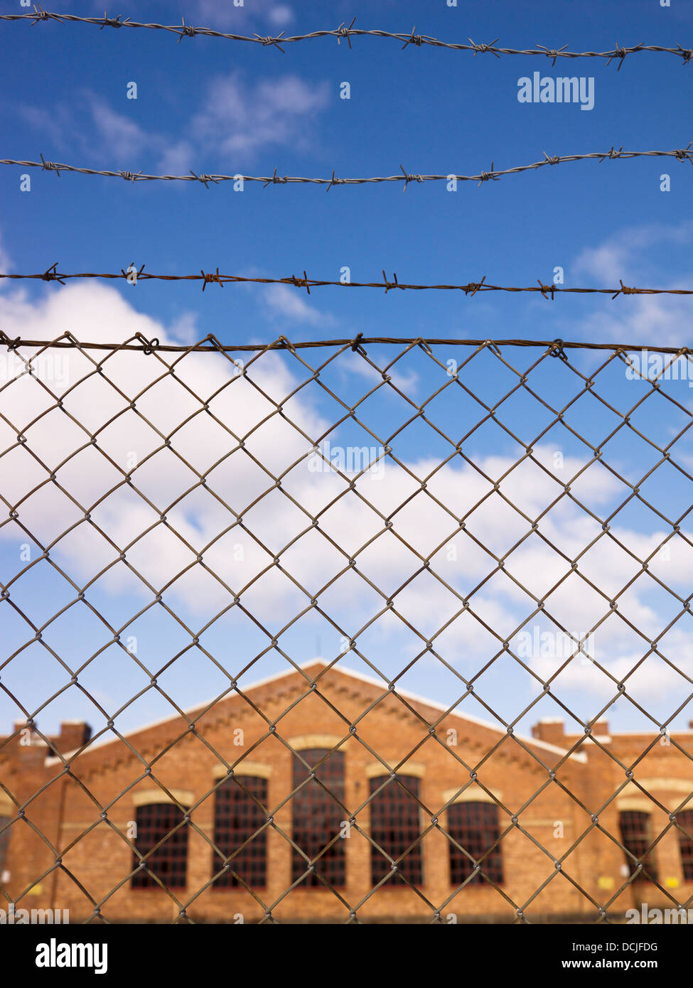 Building behind fence Stock Photo - Alamy