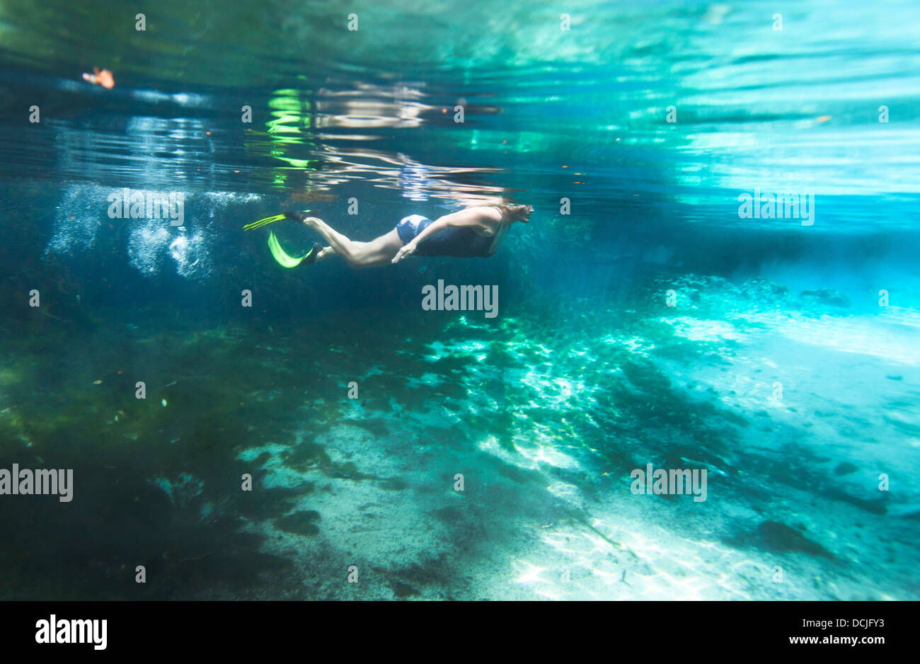 Female model swimming under water with snorkeling fins on and her head ...