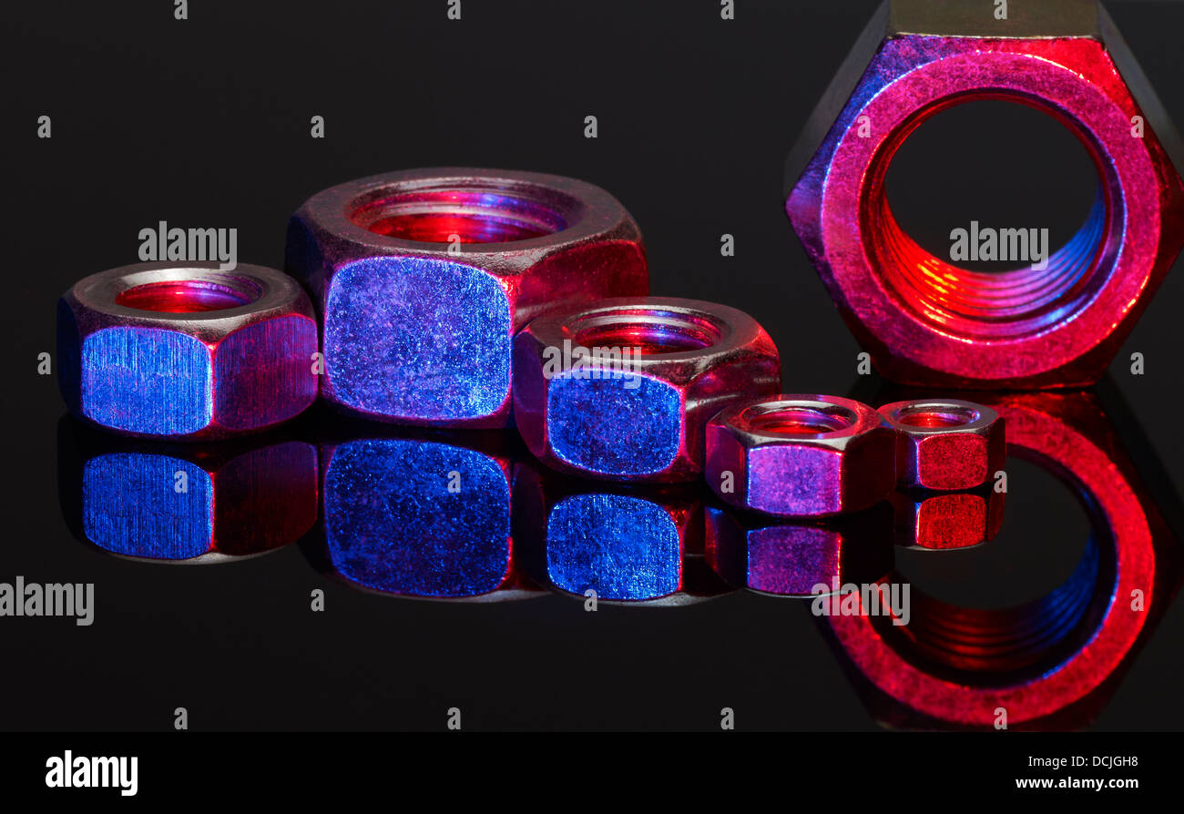 some red and blue illuminated screw nuts in black reflective back Stock ...