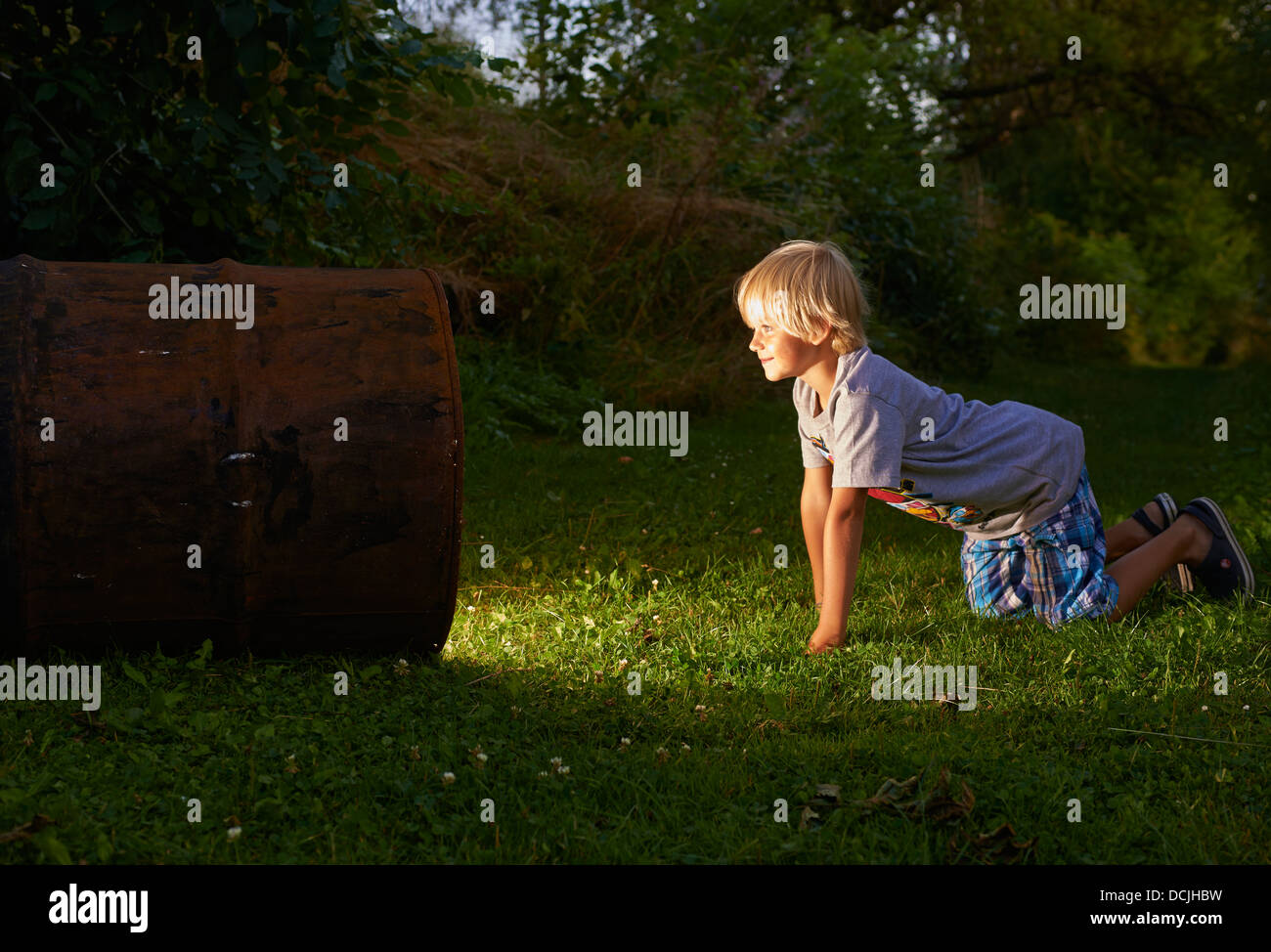 Child boy find a treasure in magic barrel at dusk Stock Photo - Alamy