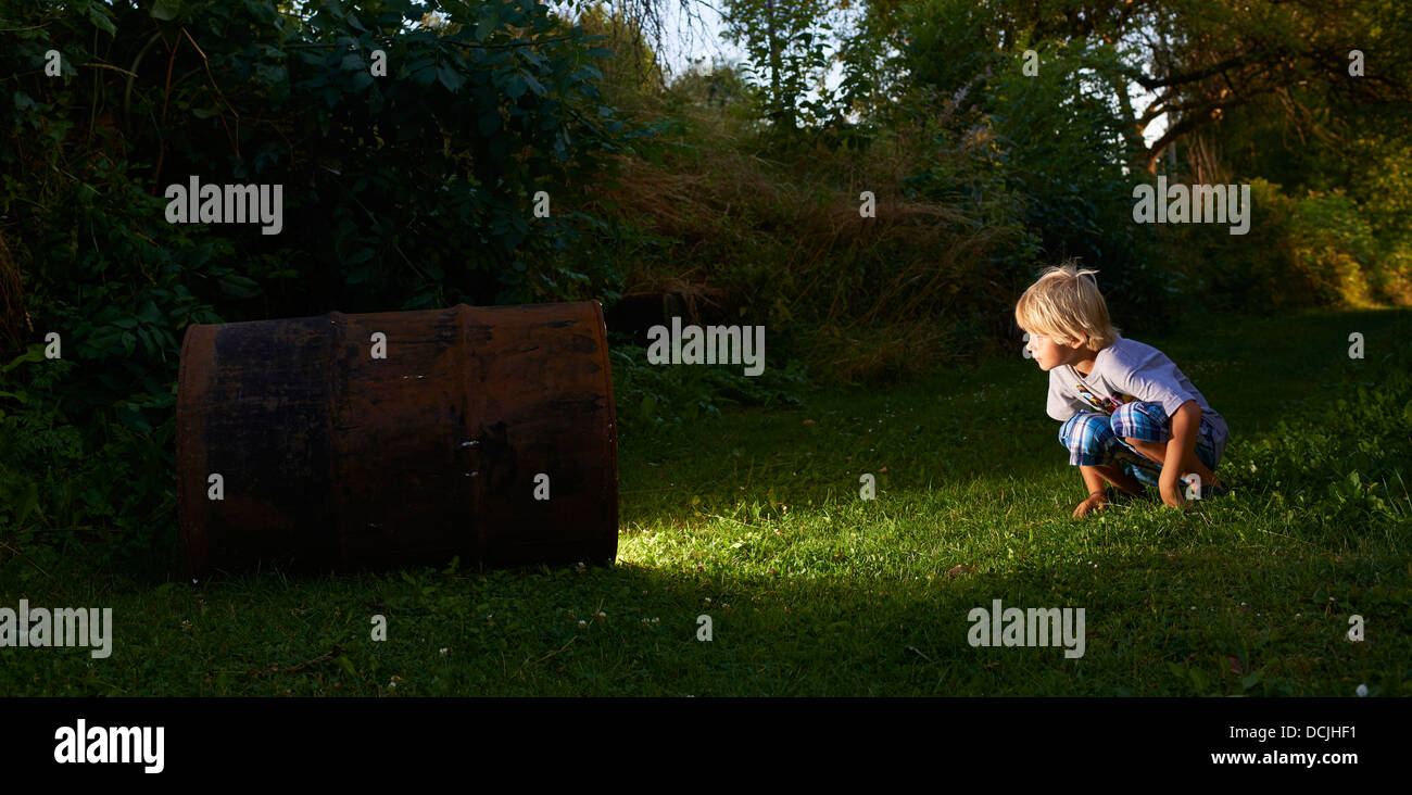 Child boy find a treasure in magic barrel at dusk Stock Photo - Alamy