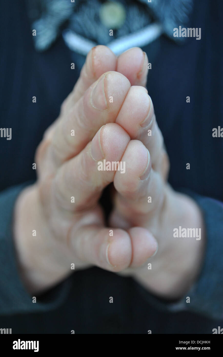 praying hands of an older person with a dark blue sweater Stock Photo ...