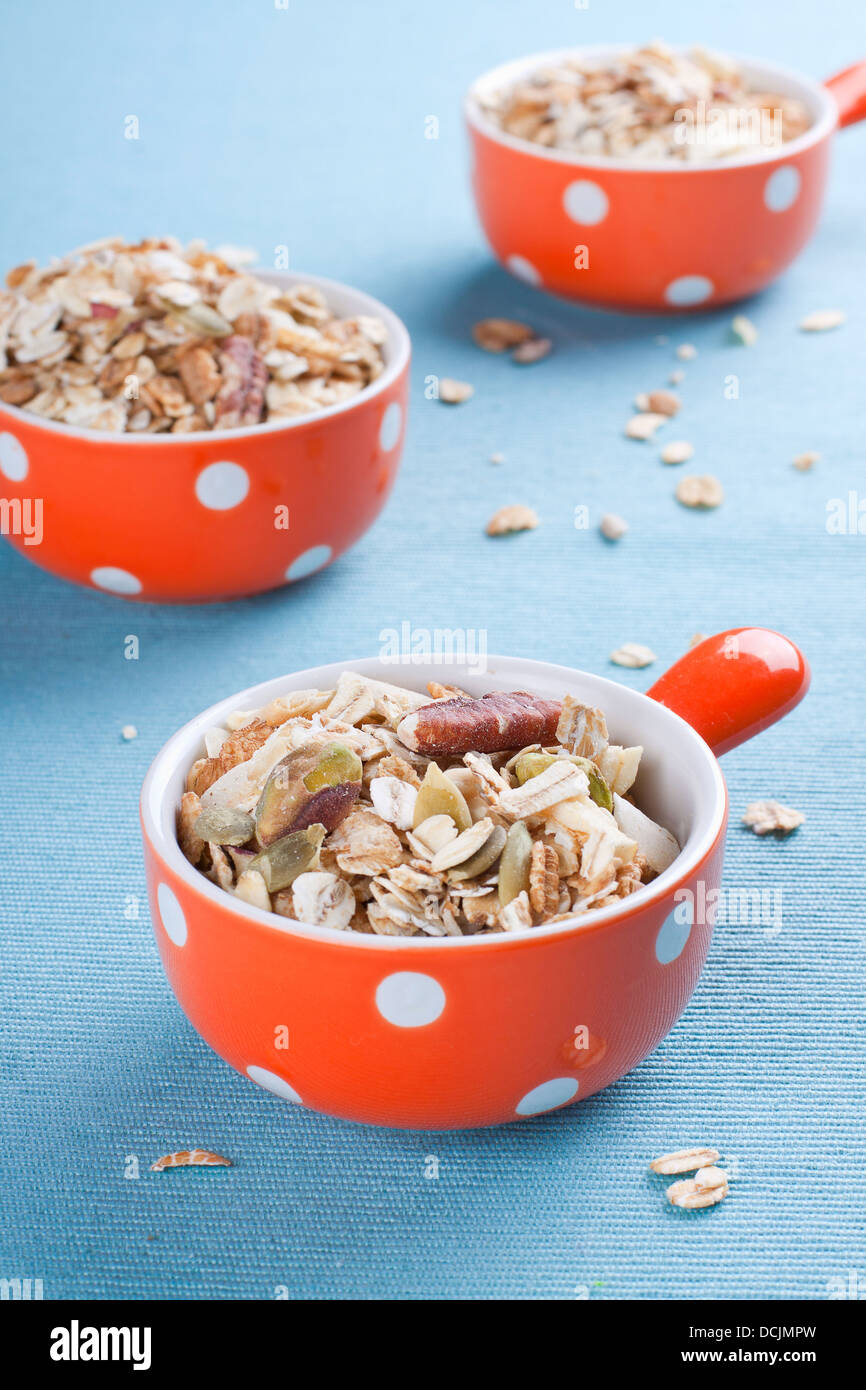 Three orange bowls full of muesli with various nuts Stock Photo - Alamy