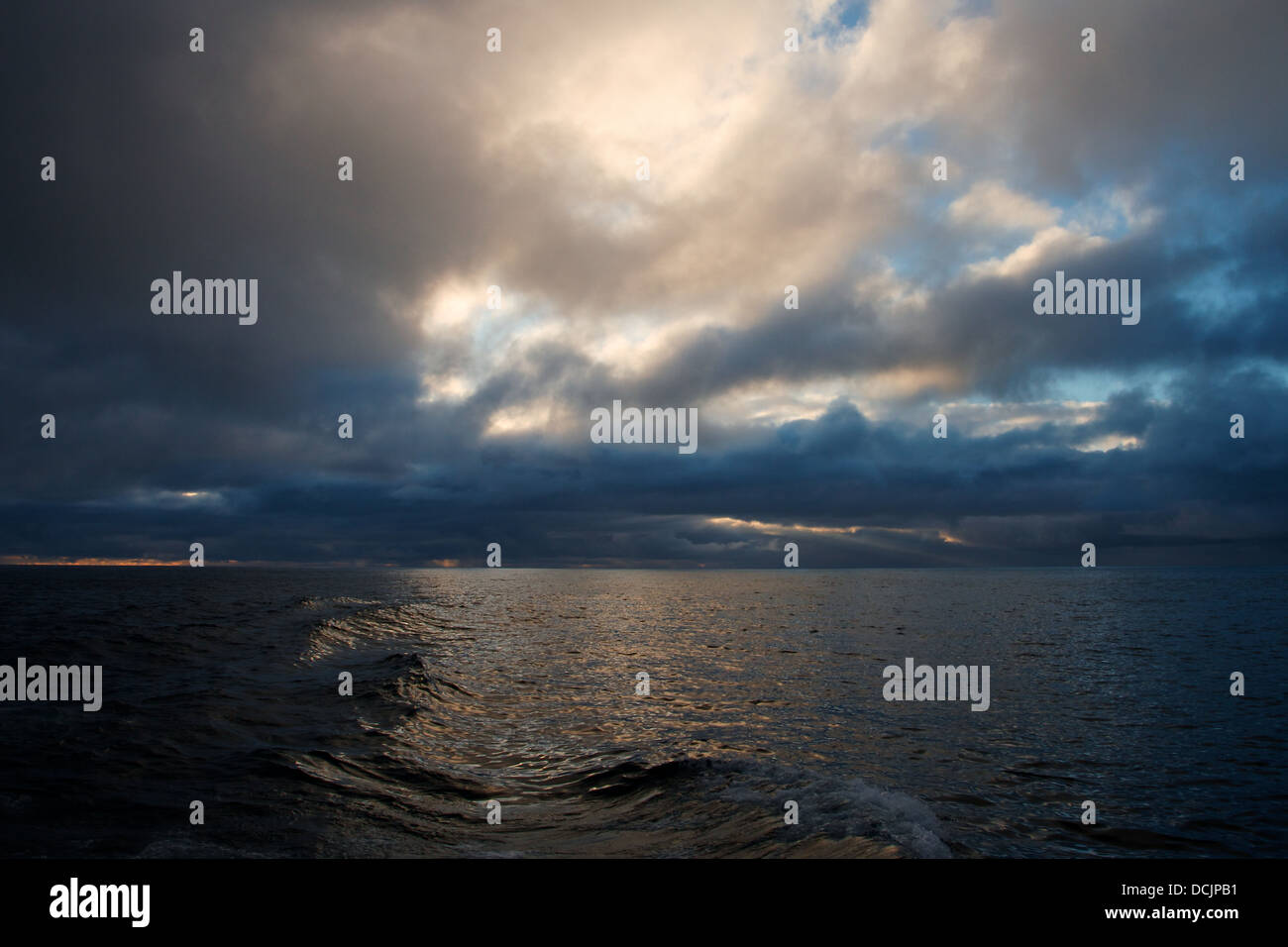 Wake from a boat in arctic at sunset Stock Photo - Alamy