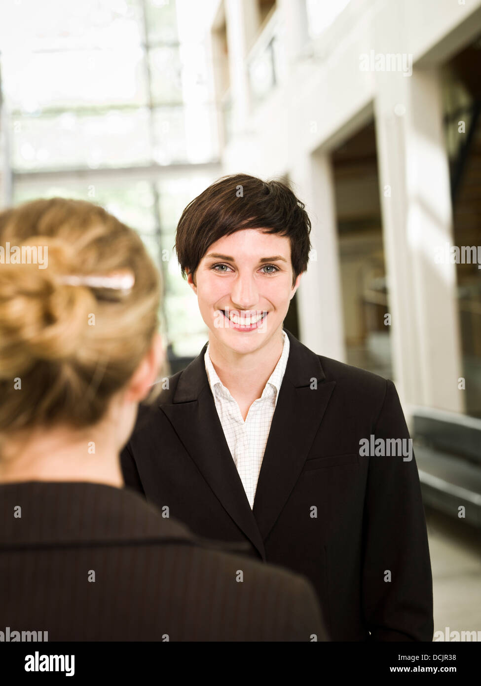 Woman facing the camera standing in a modern building Stock Photo - Alamy