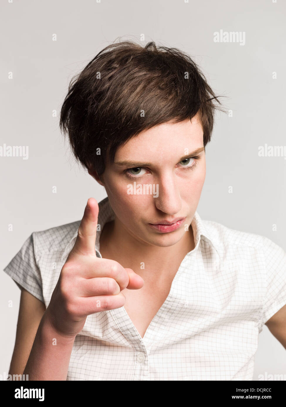 Portrait of a serious woman pointing with her finger Stock Photo - Alamy