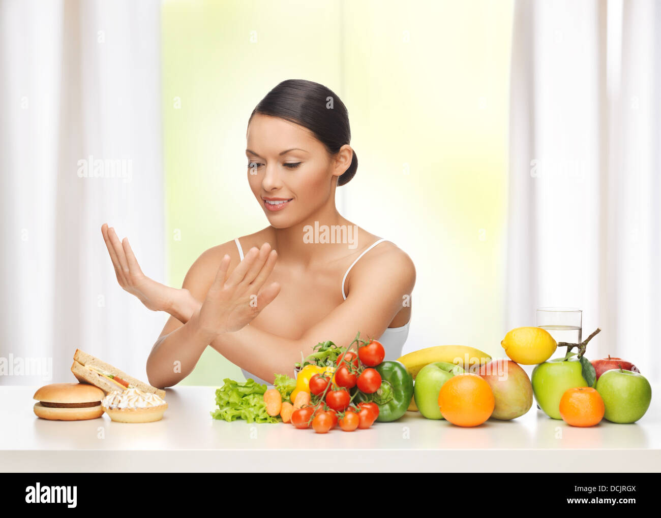 woman with fruits rejecting junk food Stock Photo - Alamy