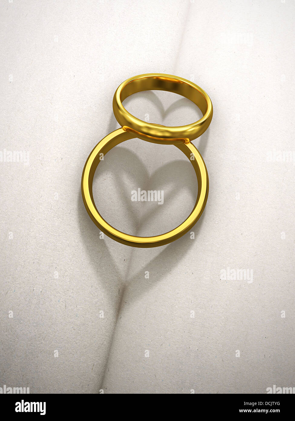 Two golden wedding rings with heart shaped shadow Stock Photo - Alamy