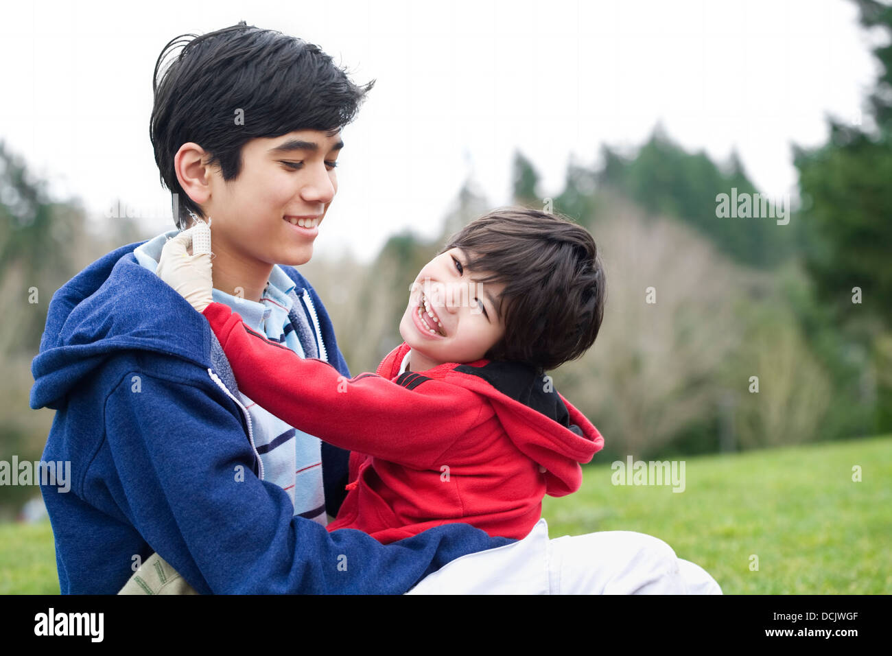 Big brother taking care of disabled little brother Stock Photo - Alamy