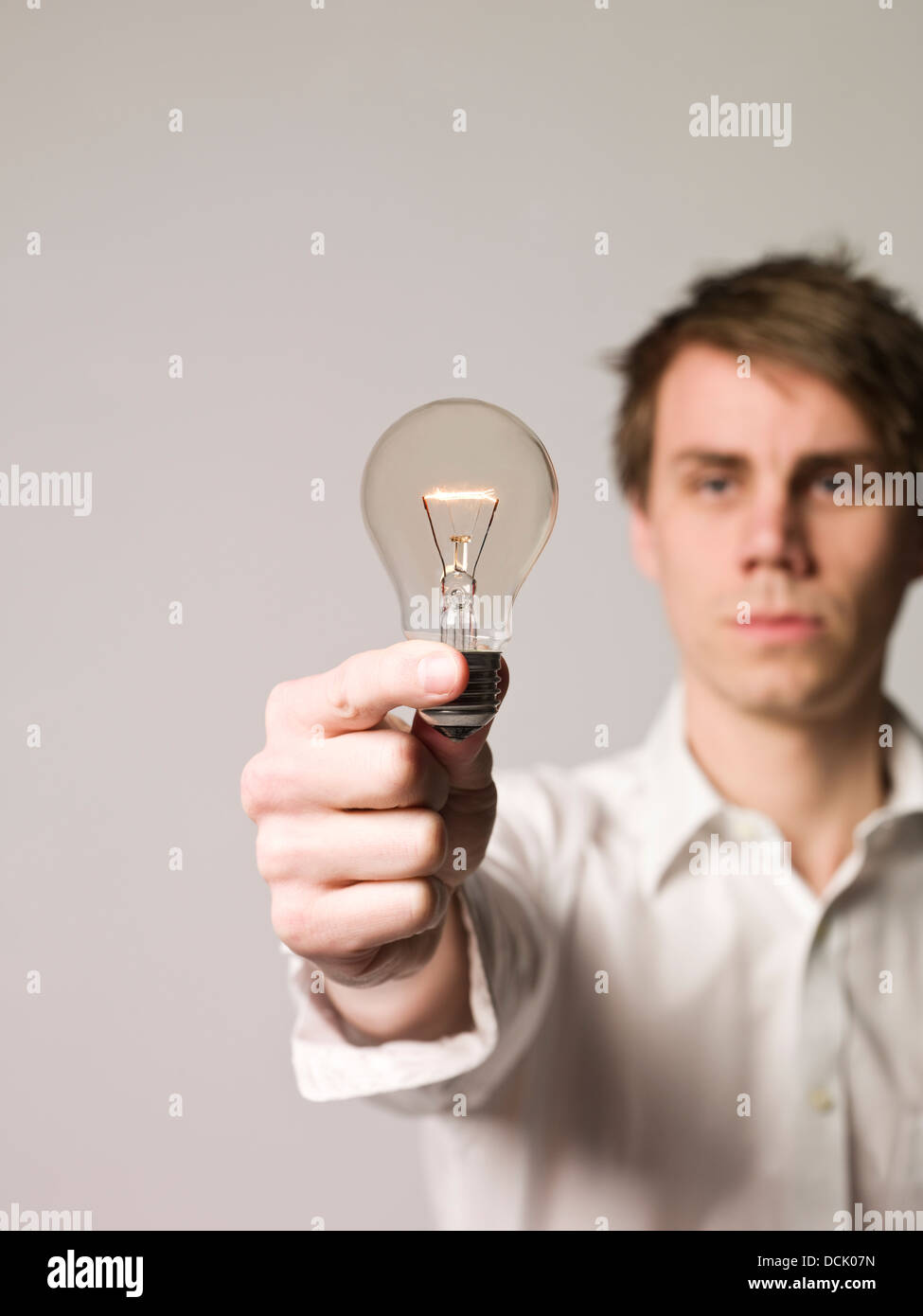 Man holding electric light bulb over his head Stock Photo - Alamy