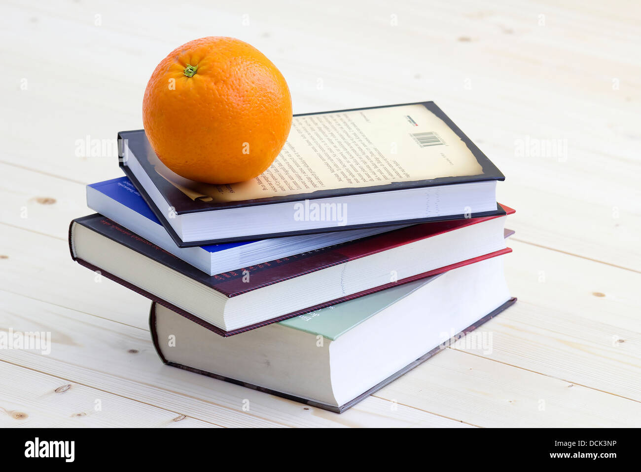 stack of books and fresh orange Stock Photo - Alamy
