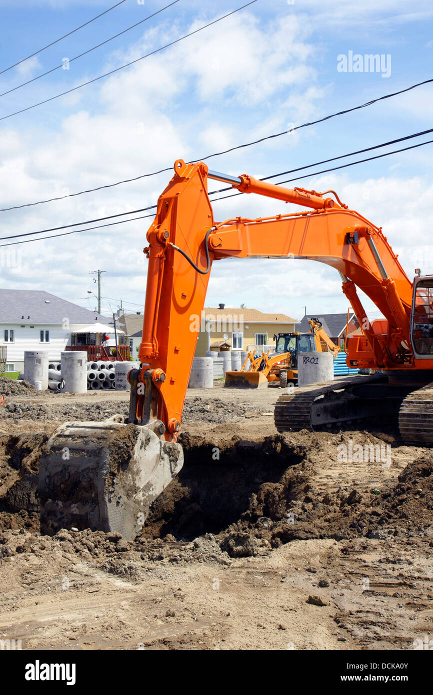 Orange digger and deep hole Stock Photo - Alamy