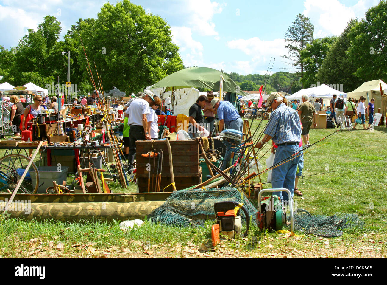 A large antique flea market sprawls out on the grass of a small town ...