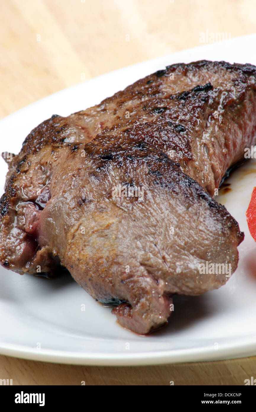 grilled ostrich steak with tomato on a plate Stock Photo - Alamy