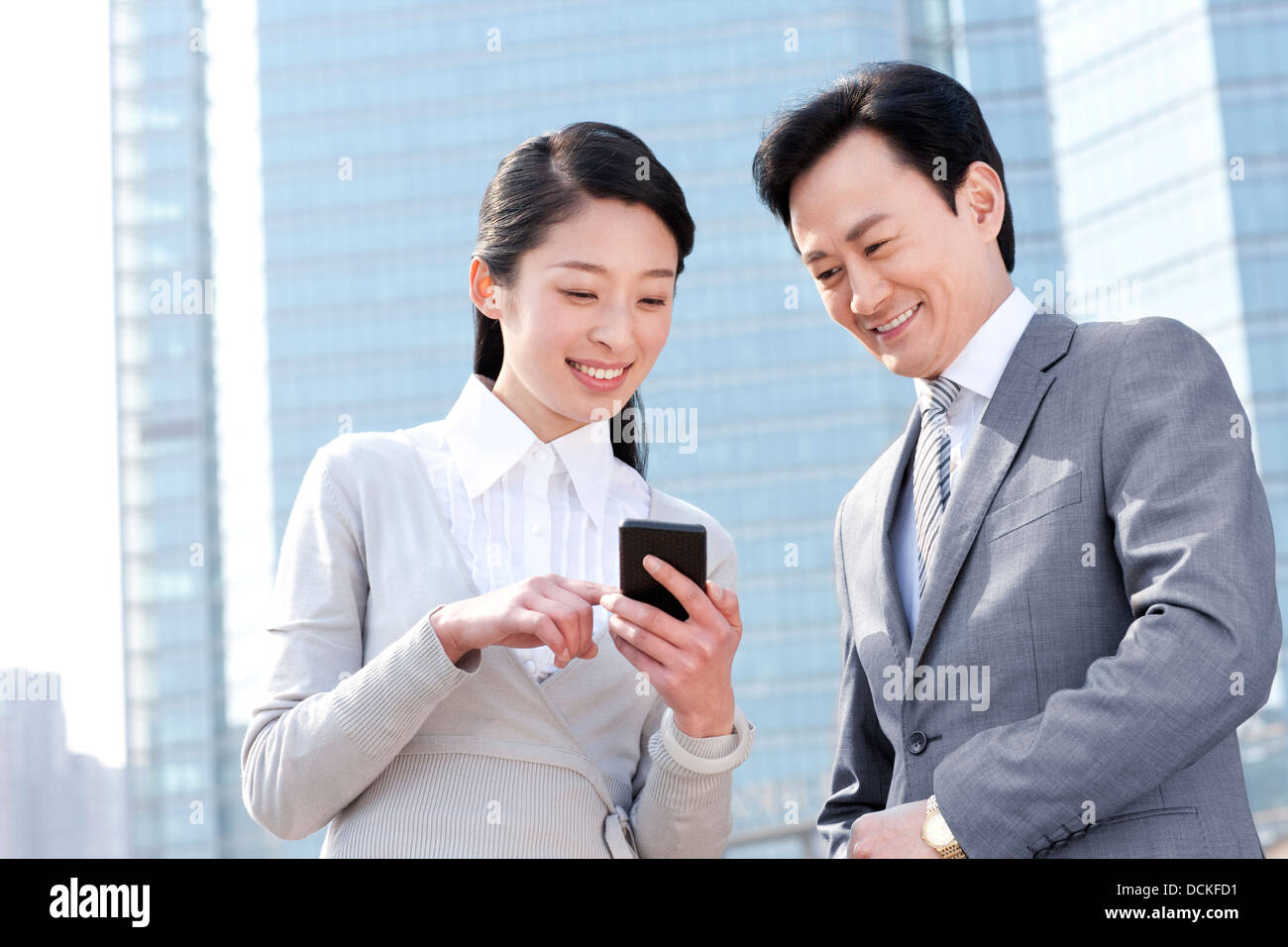 Happy business partners and mobile phone Stock Photo - Alamy