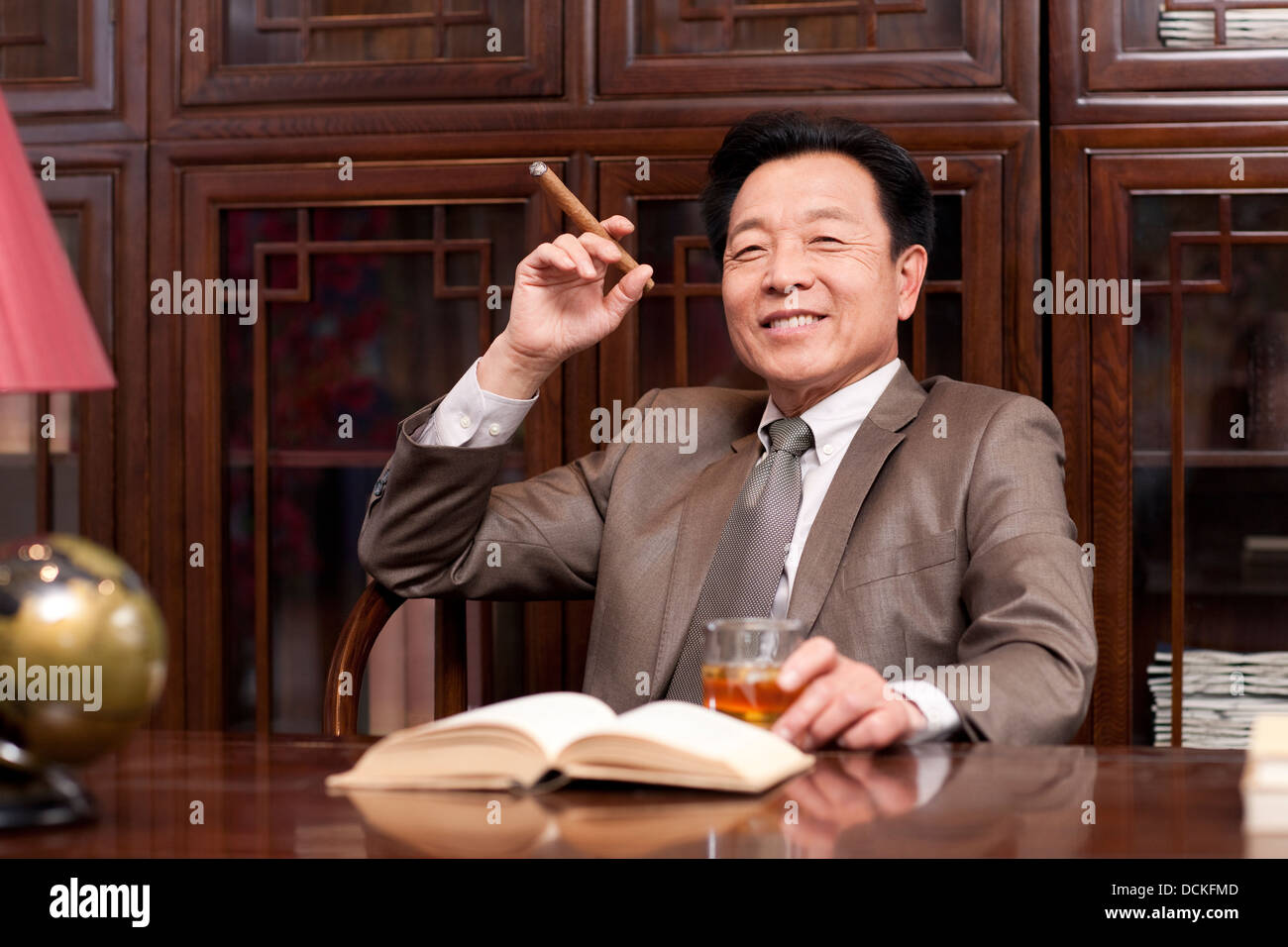 Successful businessman enjoying cigar Stock Photo - Alamy