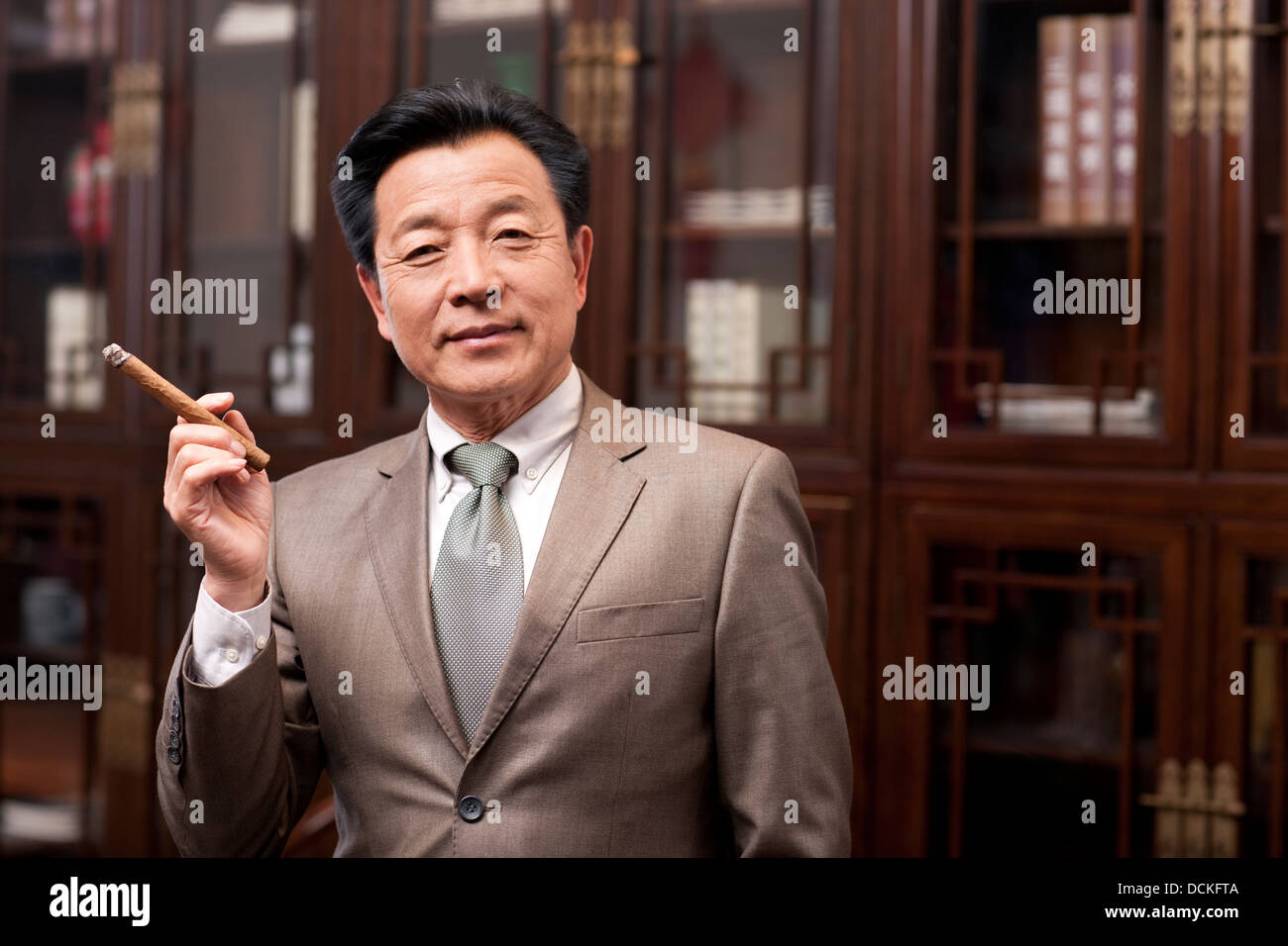 Successful businessman enjoying cigar Stock Photo - Alamy