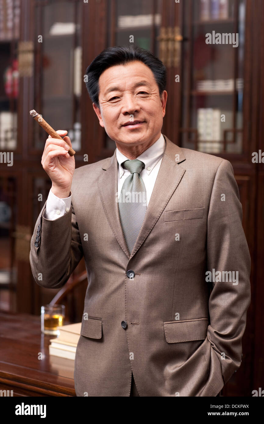Successful businessman enjoying cigar Stock Photo - Alamy