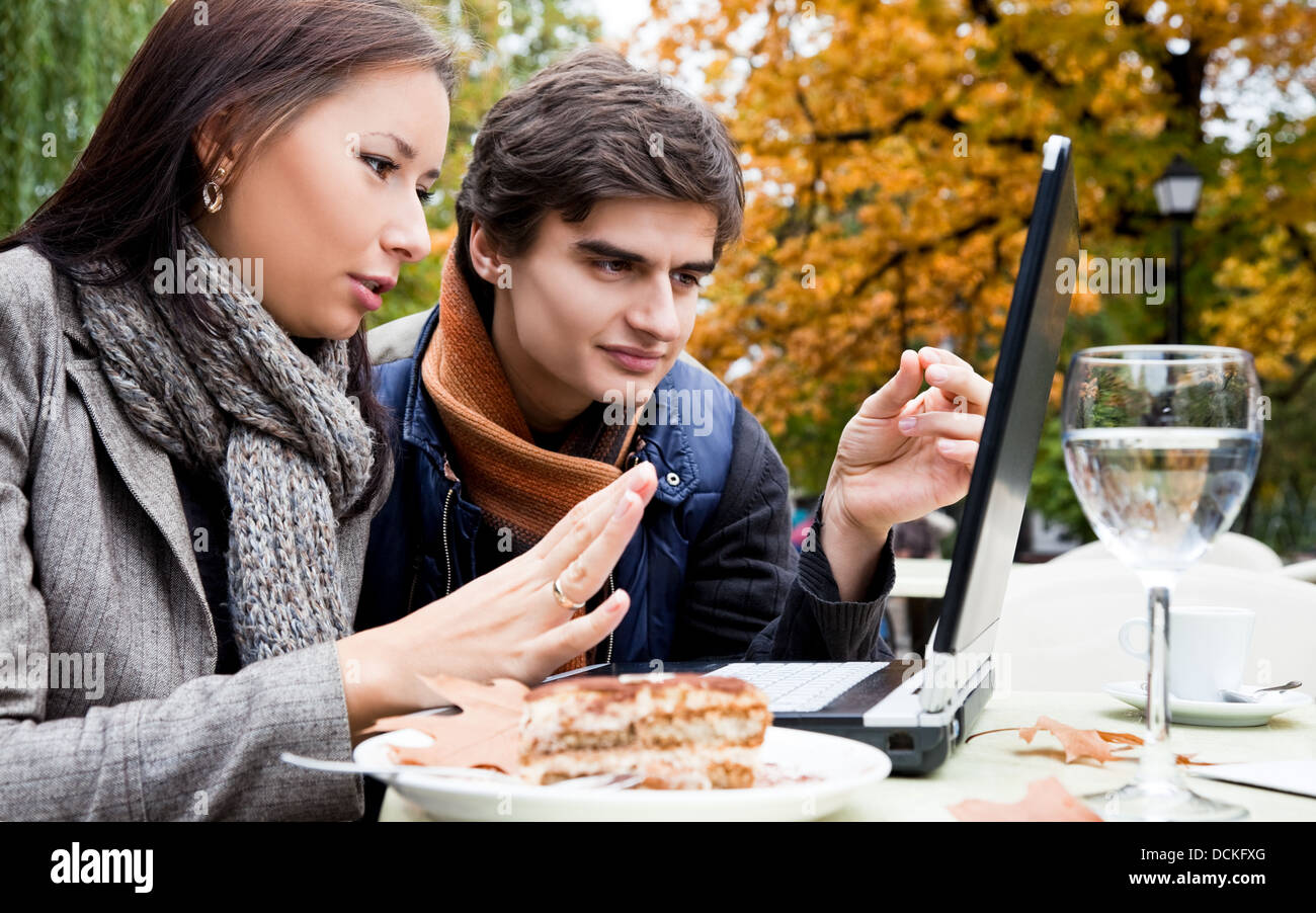 Couple sitting laptop park Stock Photo - Alamy