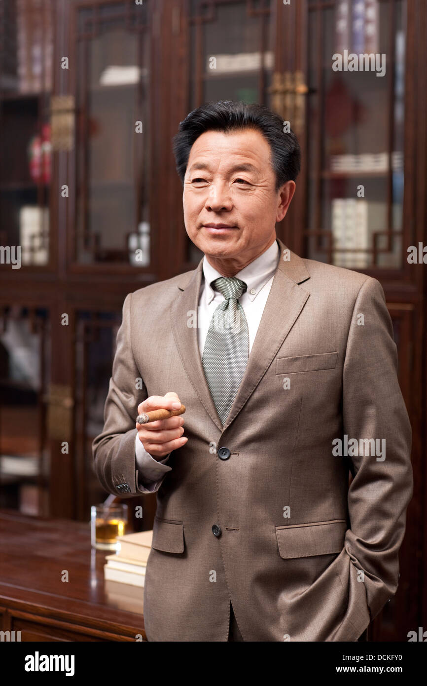 Successful businessman enjoying cigar Stock Photo - Alamy