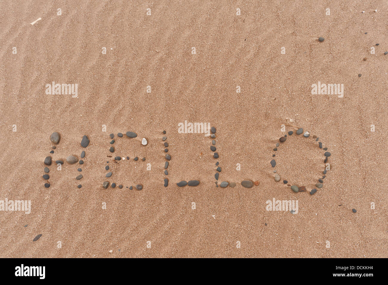Hello word made from pebbles made at low tide as sea leaves beach ...