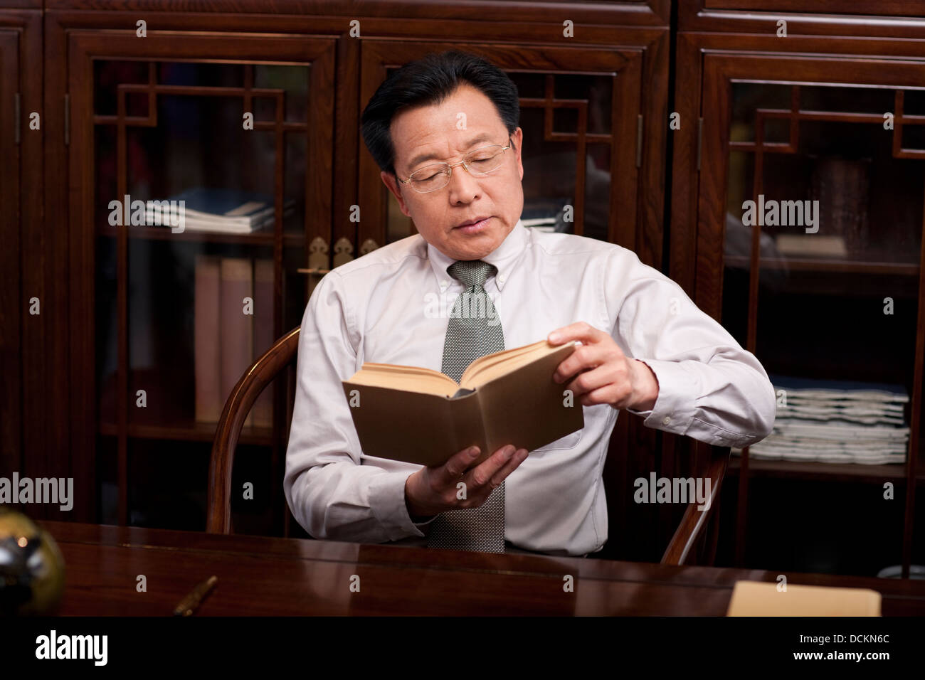 Businessman reading books Stock Photo - Alamy
