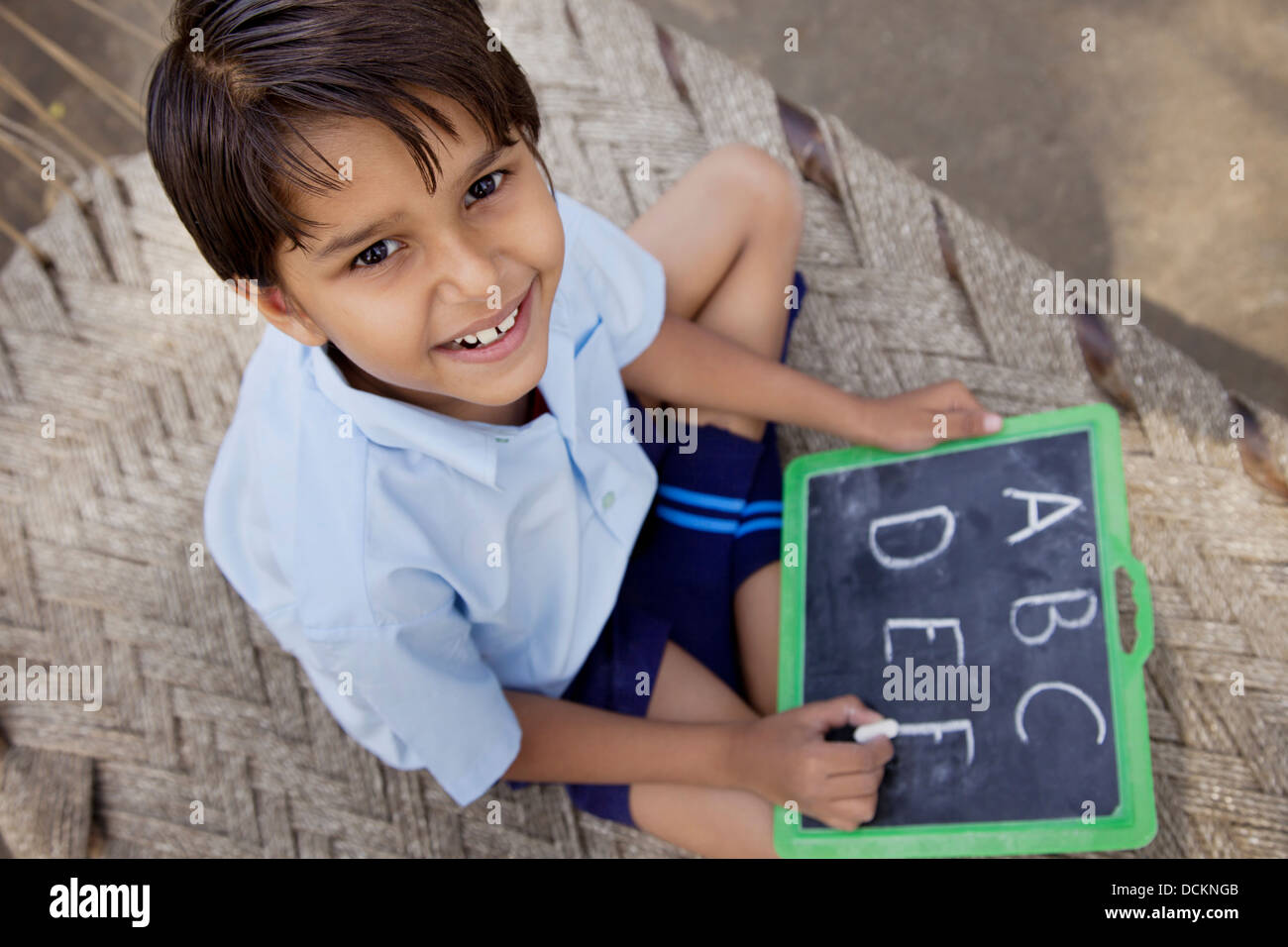High angle view of a little school boy writing on slate Stock Photo - Alamy