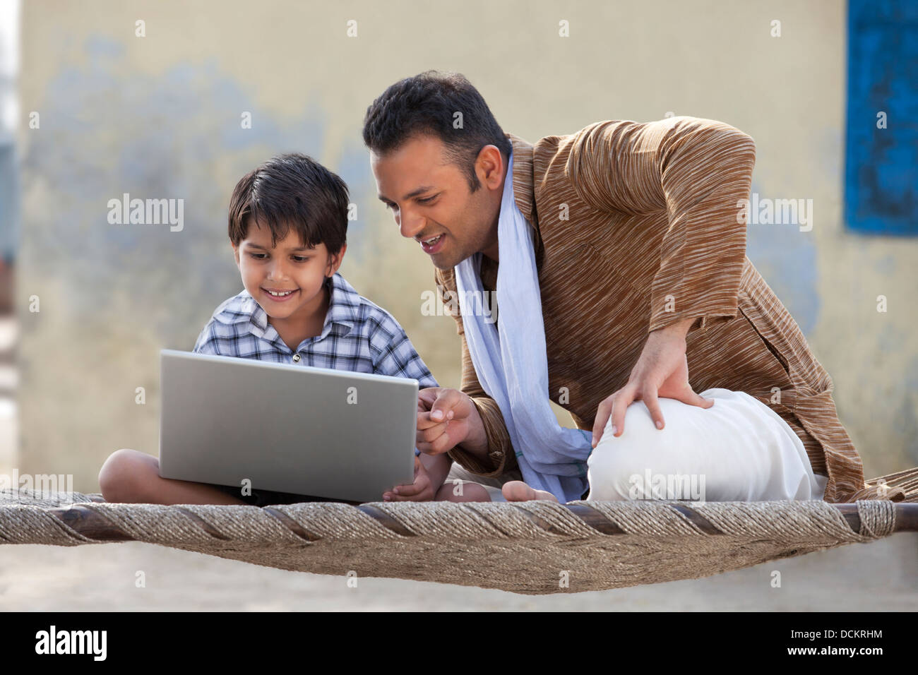 Indian father and son using laptop Stock Photo - Alamy