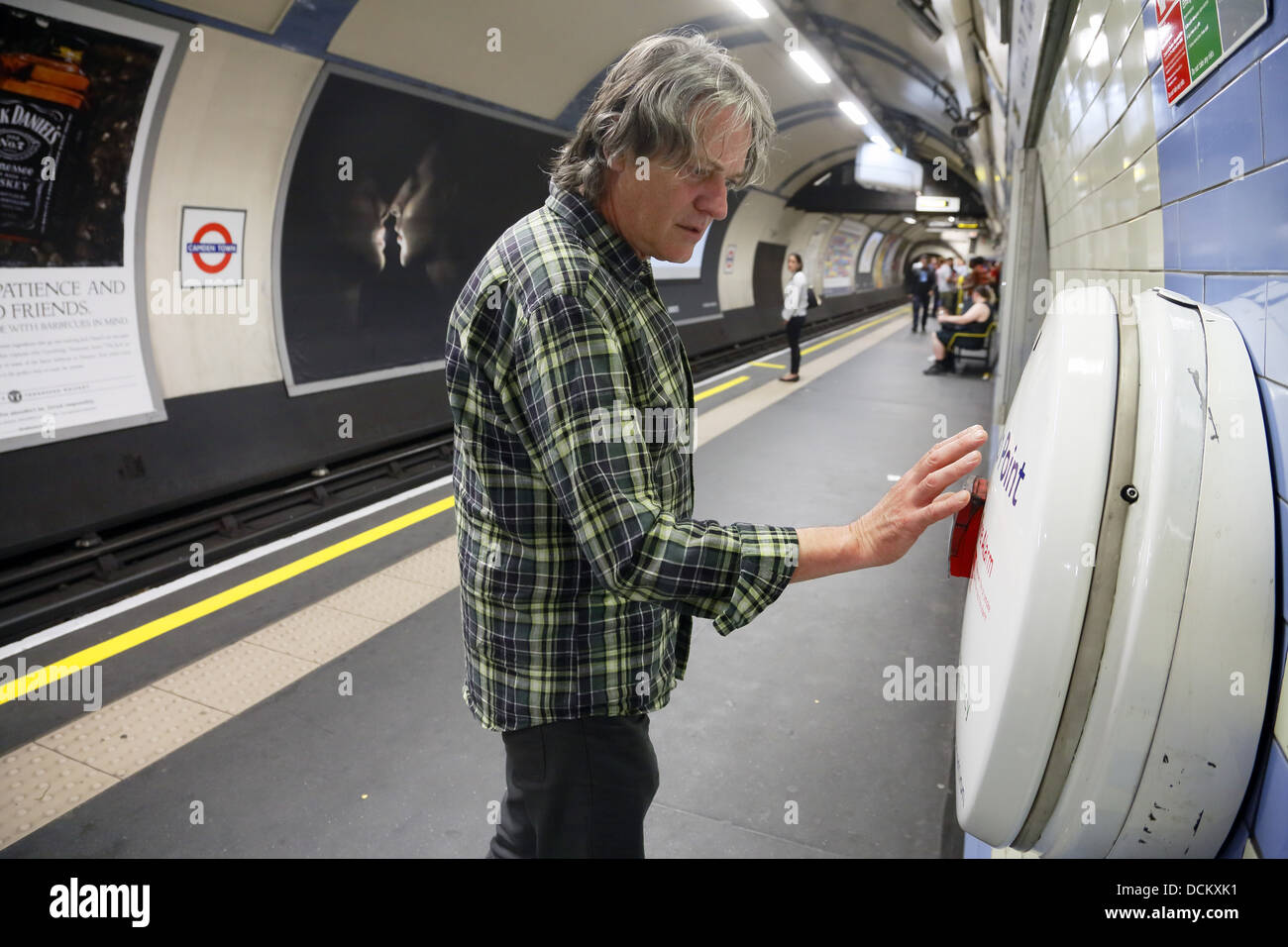 Passenger using a London underground help point Stock Photo - Alamy