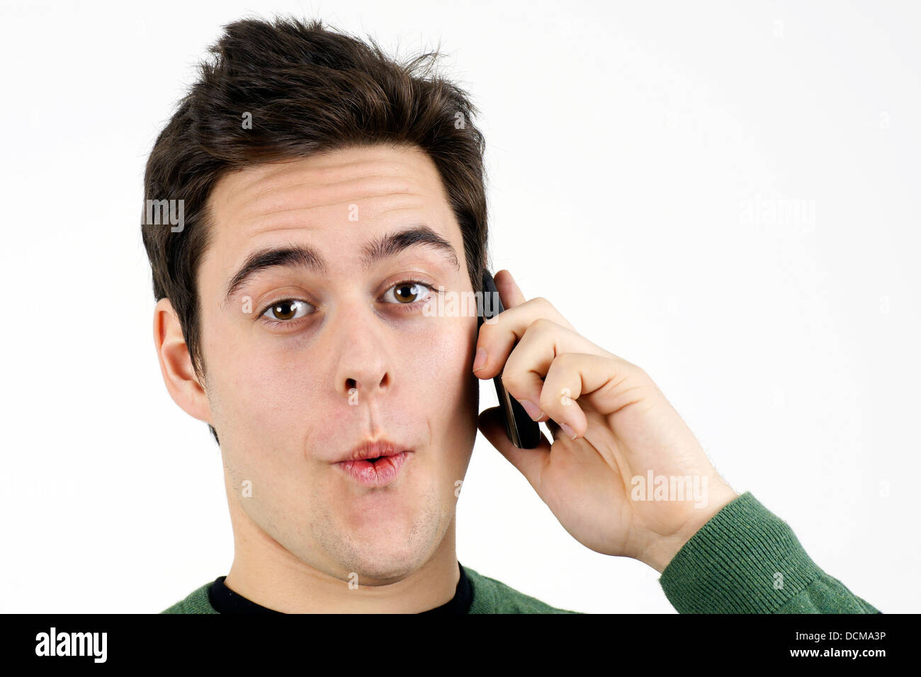 Surprised young man on cell phone Stock Photo - Alamy