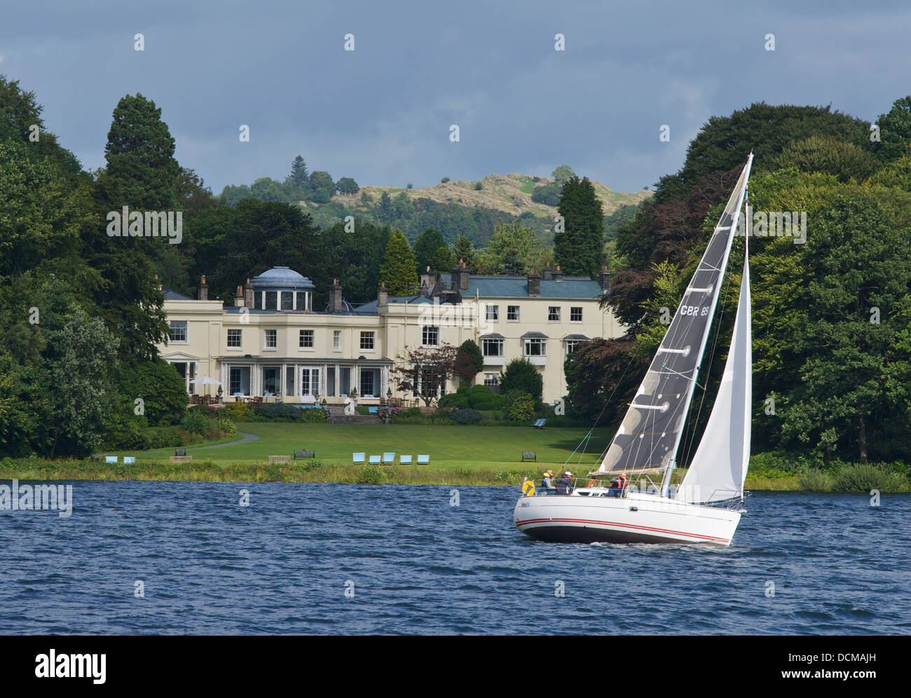 Sailing boat passing Storrs Hall Hotel, Lake Windermere, Lake District ...