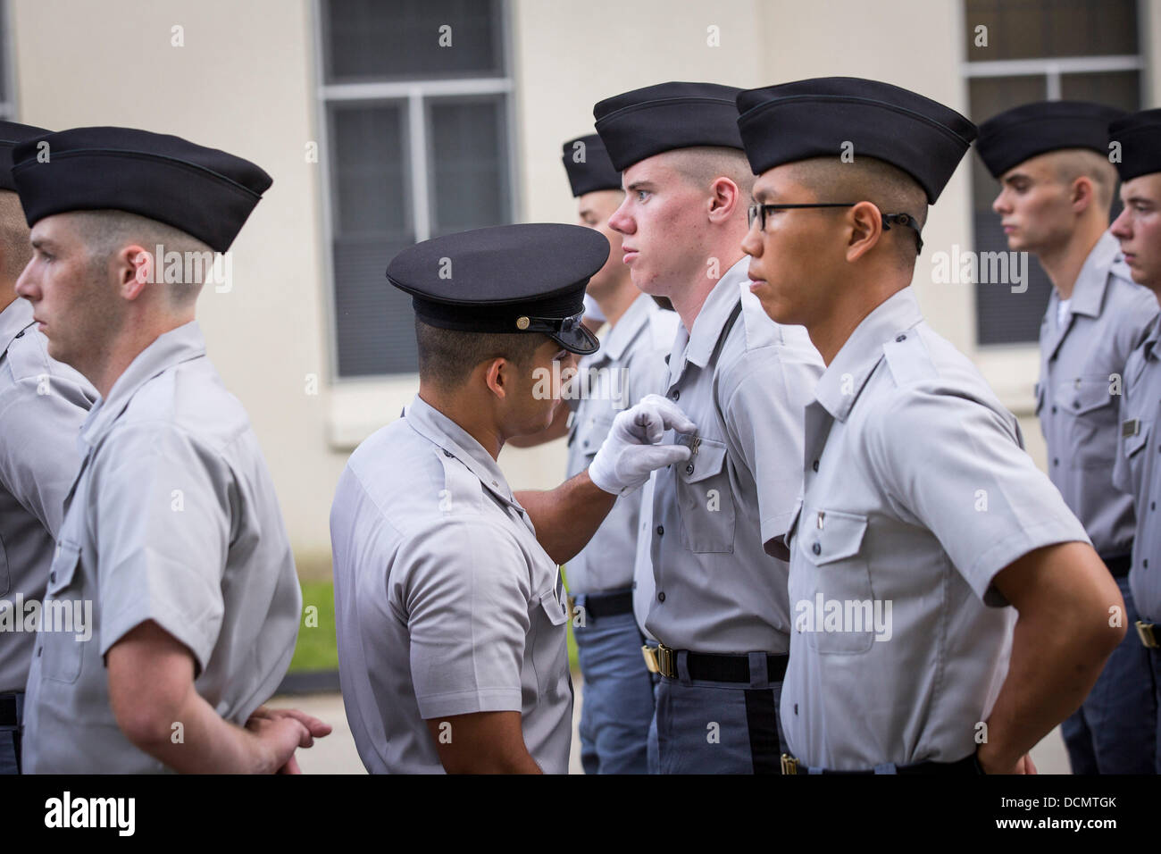 An upperclassman adjusts the new uniforms of Citadel freshmen known as ...