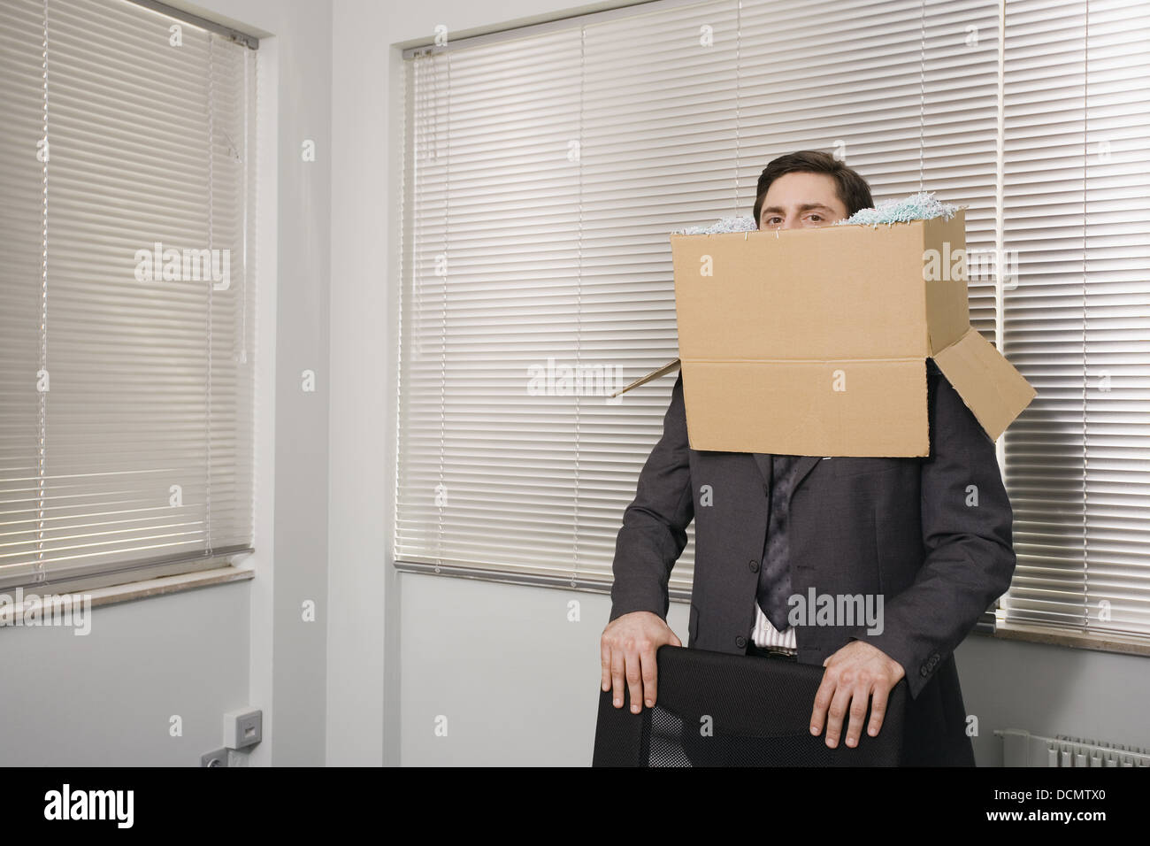 Office worker with head in a box Stock Photo - Alamy