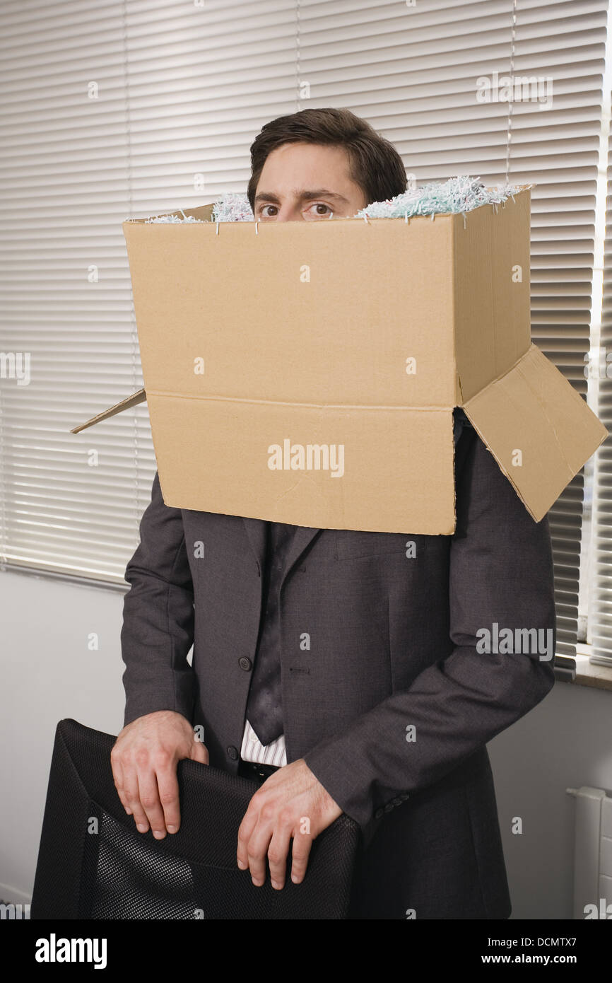 Office worker with head in a box Stock Photo - Alamy