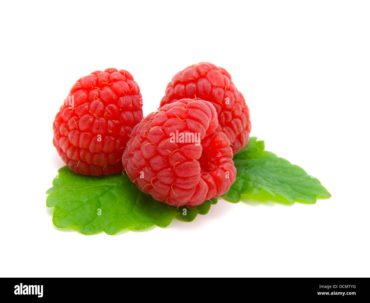 three raspberries with green leaves on white background Stock Photo - Alamy