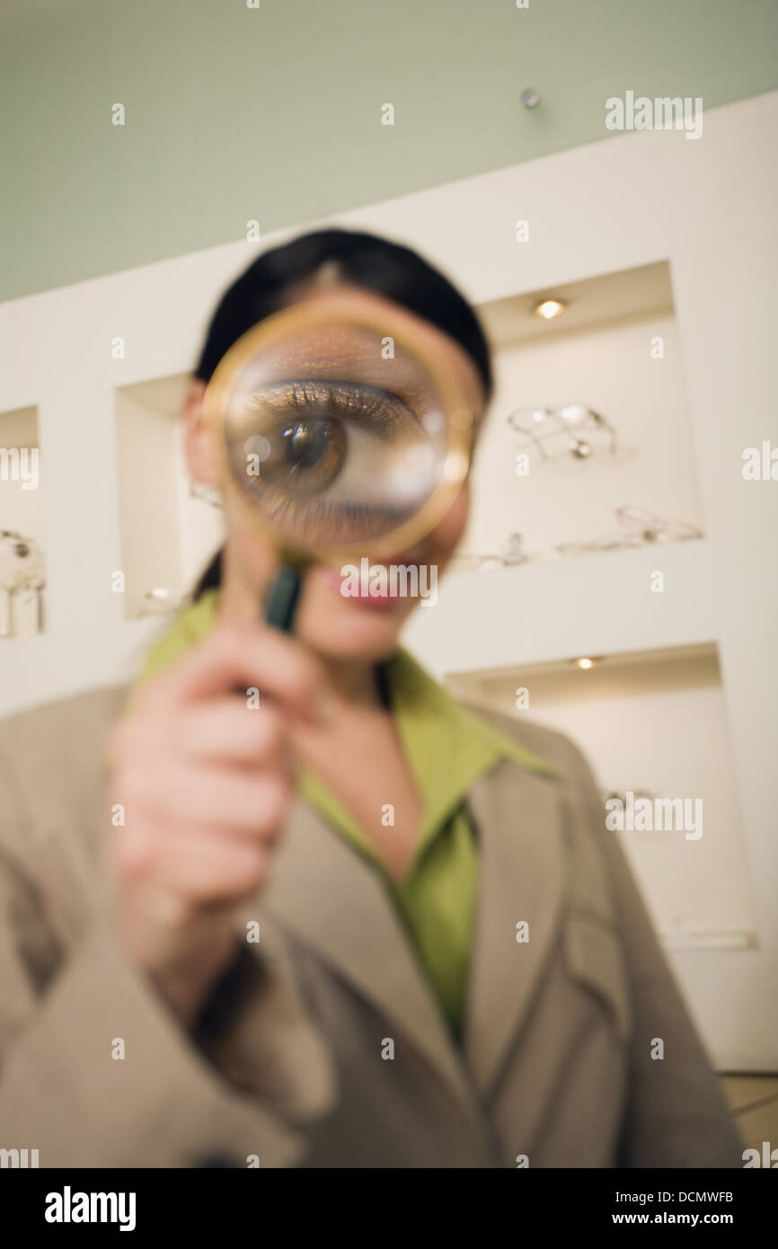 Woman with magnifying glass on eye Stock Photo - Alamy