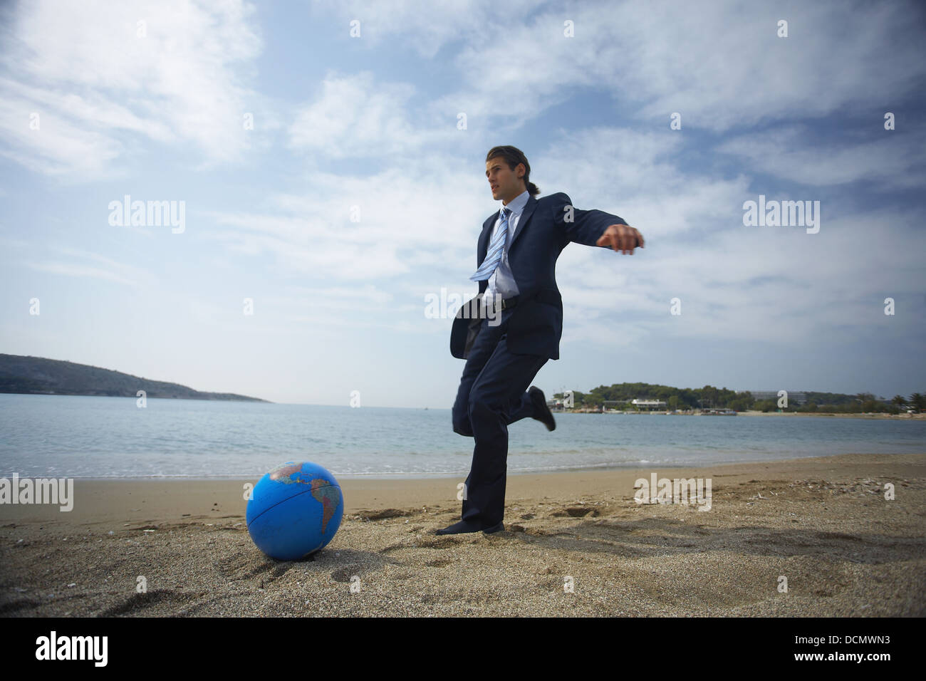 Businessman on beach with globe beach ball Stock Photo - Alamy