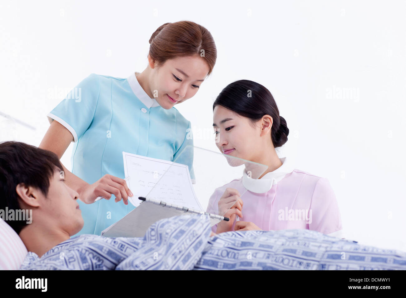 nurses taking care of a patient on a bed Stock Photo - Alamy