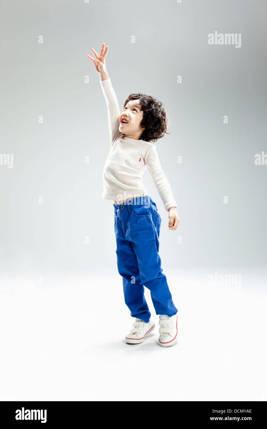 a boy jumping to reach something Stock Photo - Alamy