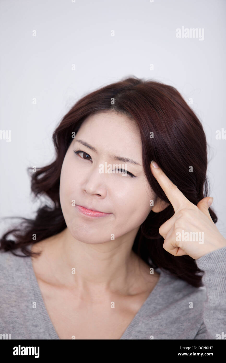 a woman in grey plain shirt thinking Stock Photo - Alamy